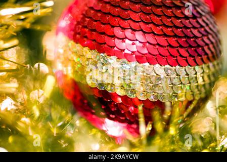 Close-up golden Christmas ball with red ribbon and scissors on white ...