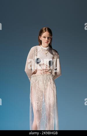 Trendy model in fishnet skirt and knitted cardigan standing isolated on ...