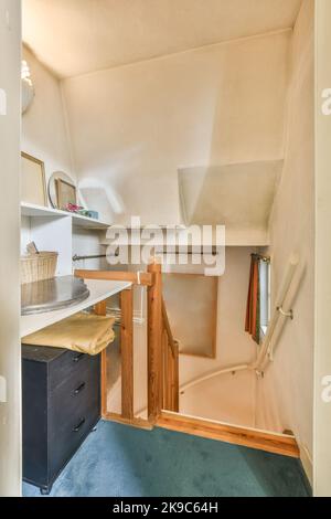 White hallway with wooden stairway leading to second floor of modern ...