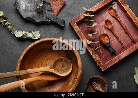 Wooden cooking utensils and eucalyptus branches on beige background ...