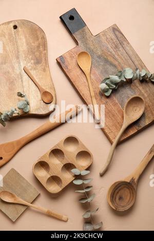 Wooden cooking utensils and eucalyptus branches on beige background ...