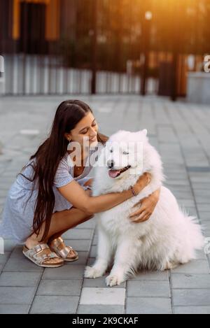 A young woman hugs a big dog at sunset in summer Stock Photo - Alamy