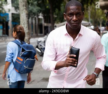Man running away with stolen wallet Stock Photo - Alamy