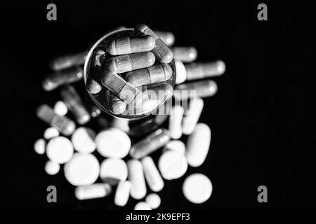 Starch capsules gel caps medication in glass dark background, caplets ...