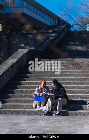 Young innocent high school girls are sitting on the stairs after school ...