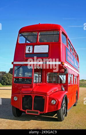 Colorful red double-decker bus moves quickly through motion blur effect ...
