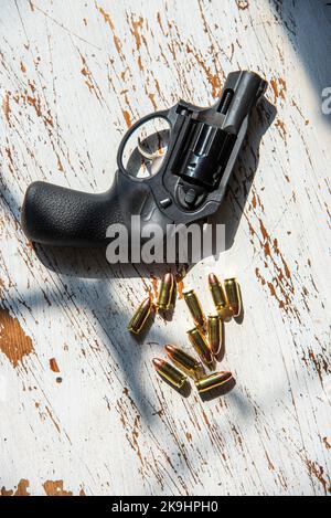 A black, Ruger, 9mm, snub-nosed revolver and a grouping of 9mm bullets ...