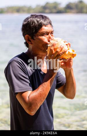An asian muslim filipino man using a conch shell trumpet in Sulu ...