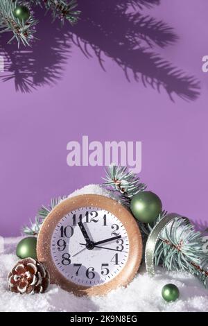 Alarm clock with Christmas balls and fir branches on dark wooden ...