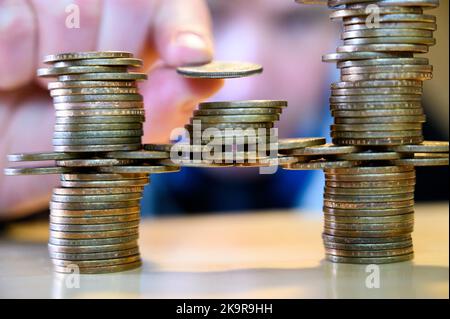 stacking gold dollar coins into bridge using a cantilever Stock Photo ...