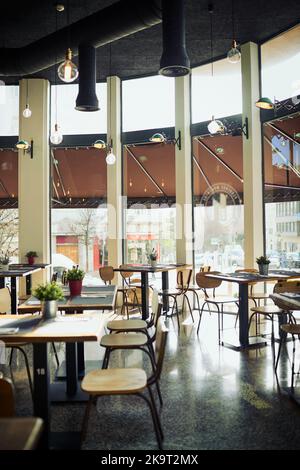 An empty cafe filled with chairs and tables along with interior ...