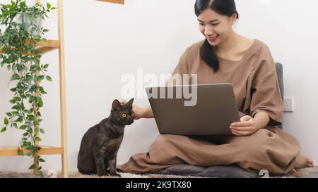Pet lover concept, Young Asian woman using laptop and playing to ...