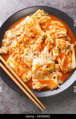 top view of tasty kimchi in jars, chopsticks, green onions and ginger ...