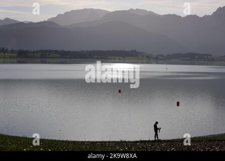 Rieden, Germany. 30th Oct, 2022. A man is standing in the sunshine on ...