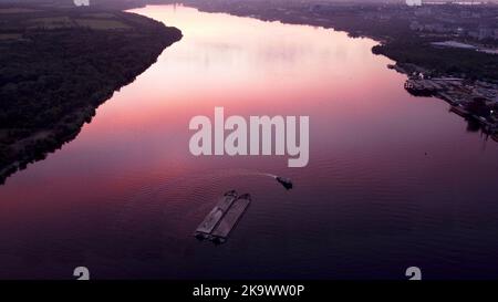 boat and barge with sand sails along the coast along the wide river on ...