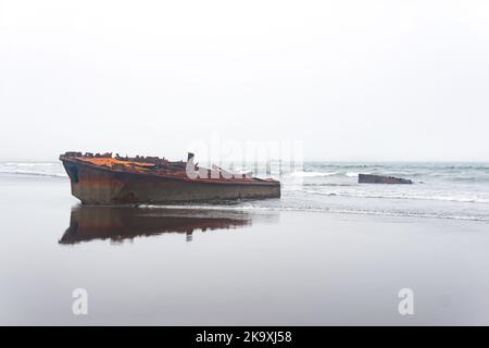 rusty shipwreck, fragments of a ship washed ashore against a foggy ...