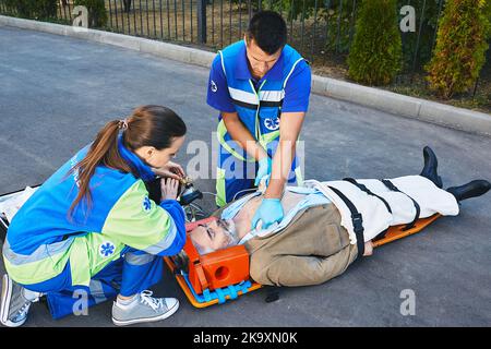 Ambulance paramedic with defibrillator performing cardiopulmonary ...
