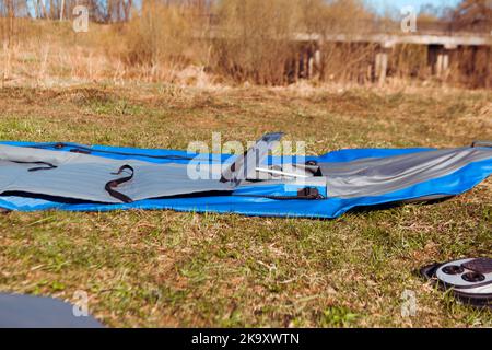 Deflated rubber boat and a pump on the grass Stock Photo - Alamy