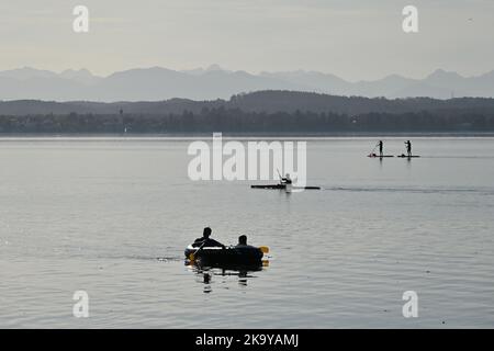 Ambach, Germany. 30th Oct, 2022. Stand-up paddlers and swimmers enjoy ...