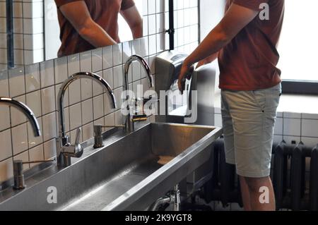Stainless steel handwashing sink in a modern prison, lighting, toning ...