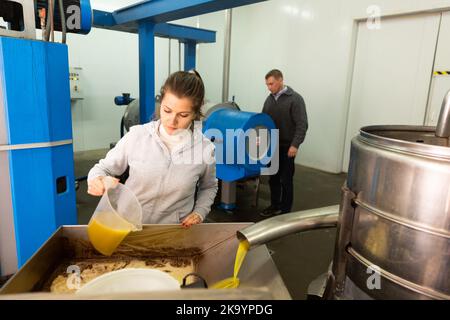 Woman controlling process of oil decanting Stock Photo - Alamy