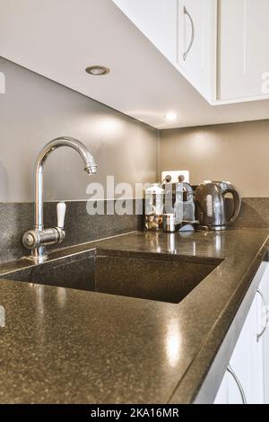 Contemporary open plan kitchen with dining table set and gray sofa in ...