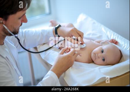 Male pediatrician listening babys heart with the stethoscope Stock ...