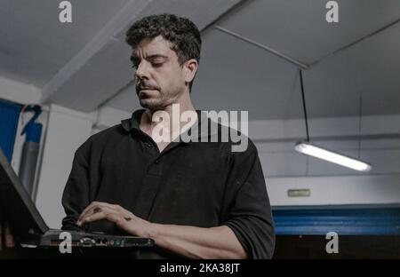 Car mechanic working on laptop in workshop Stock Photo - Alamy