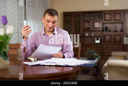 Concentrated man filling out papers Stock Photo - Alamy