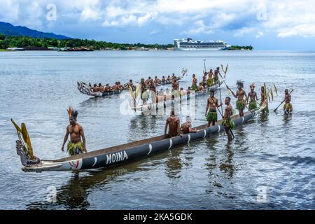 Indigenous paddlers in traditional costume demonstrating paddling ...