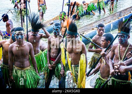 Indigenous paddlers in traditional costume demonstrating paddling ...