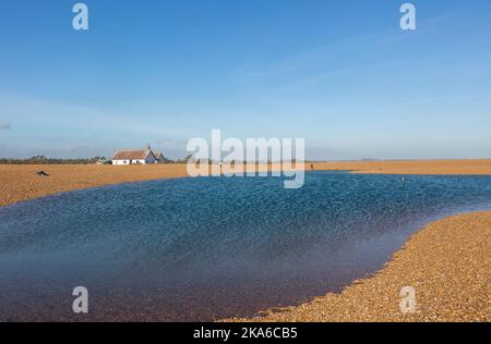 Lagoon of water used by swimmers on beach at Shingle Street, Suffolk ...