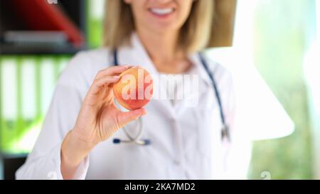 Female doctor nutritionist holding ripe yellow apple in hand Stock ...