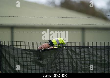 A member of security staff secures screens around the Manston ...