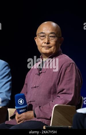 Chinese poet and writer Liao Yiwu speaks into a microphone during a ...