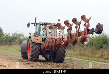 Tractor and plough attached. Various shots of tractor ploughing a field ...