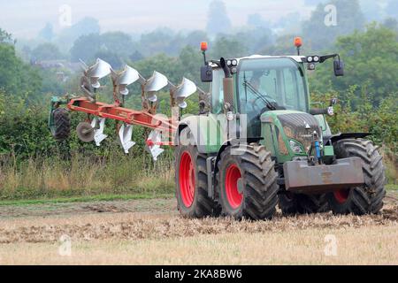 Tractor and plough attached. Various shots of tractor ploughing a field ...