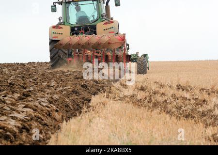 Tractor and plough attached. Various shots of tractor ploughing a field ...