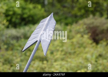 Metal arrow tip pointing right in spring, concept: target, focus, task ...