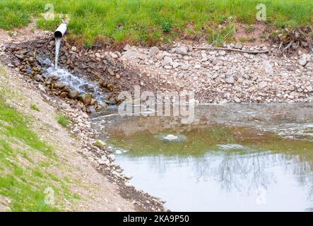 Discharge of polluted water through a pipe, toxic, flow, waste water ...