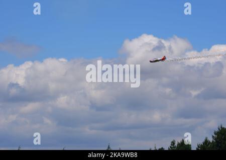 Plane flying within dark clouds with smoke on tail Stock Photo - Alamy