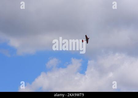Plane flying within dark clouds with smoke on tail Stock Photo - Alamy