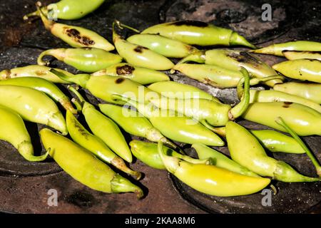 Roasting green chili peppers on outdoor fire pit of farmhouse Stock ...