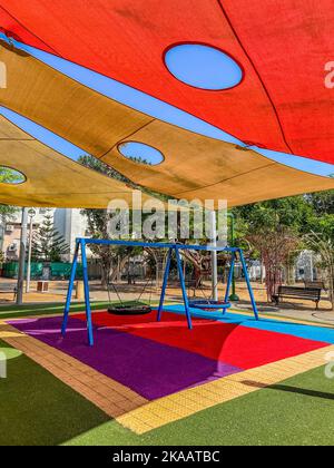 Modern playground with colorful swings and spring riders on a safe ...