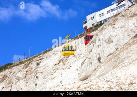 A view to funicular cabins lifting up to the mountains covered by thick ...