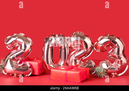 Figure 2023 made of balloons with Christmas decor and glass on beige ...