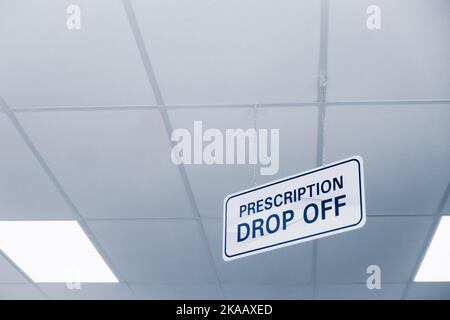 Plain white and blue prescription drop-off sign hanging from an ...