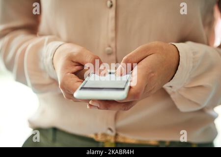 Keeping in touch. Cropped shot of an unrecognizable businesswoman using ...