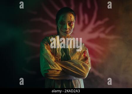 Young woman portrays bloodthirsty zombie with horror wounds on her face ...