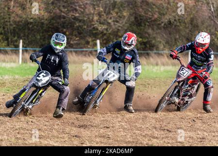 GT140 solo class riders racing in a grasstrack motorcycle race. Donut ...